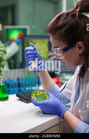 Genetic laboratory researcher taking sample from test tube in clinic ...