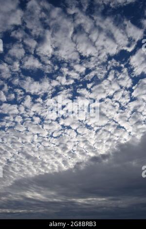Blue sky with light broken cloud cover Stock Photo - Alamy