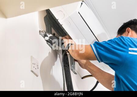 Technician installing indoor air conditioner compressor condenser ...