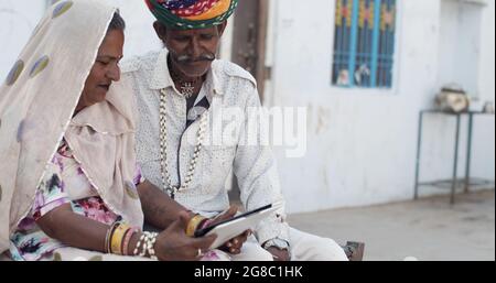 Elder South Asian couple in traditional Indian clothing posing together ...
