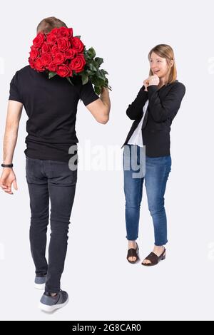 Happy young delivery man with bouquet of beautiful tulips on grey ...