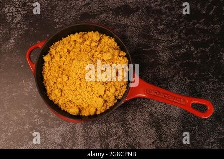 red iron pot with Farofa. Traditional Brazilian food. On a dark ...