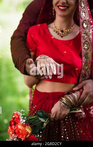 cropped view of bridegroom with golden ring on finger hugging happy ...