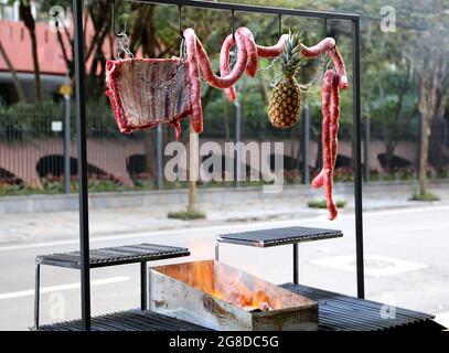 Argentine barbecue parrilla on the sidewalk in a street in Brazil. With ...