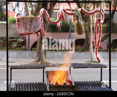 Argentine barbecue parrilla on the sidewalk in a street in Brazil. With ...