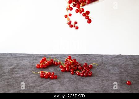 Red currants falling on a gray cloth background Stock Photo - Alamy