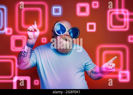 Fat happy man with beard ,tattoos and wings acts like an magic fairy ...