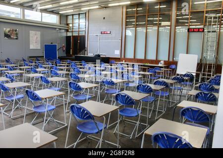 english school hall full of lines of chairs and tables for examinations ...