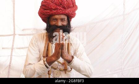 Old Indian man greeting with his palms together in a namaste gesture ...