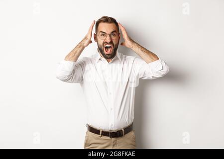 Frustrated man panicking, shouting and looking anxious, standing over ...
