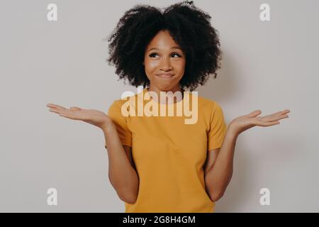 Clueless young woman with an indifferent face expression shrugging her ...