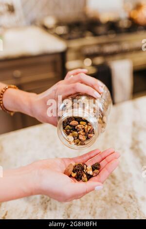 close up of hand pouring nuts to paper bag Stock Photo - Alamy