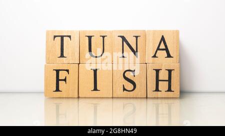 Tuna phrase created from wooden letter cubes. Seafood and food. close ...