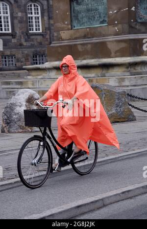 COPENHAGEN /DENMARK-Female bicyclist bicycling in rain today on ...