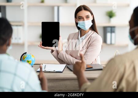 Tour Agent Showing Tablet Screen To Tourists Offering Vacation Indoor ...
