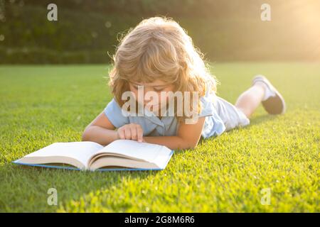Smart clever Kids. Cute lovely child reading book outside. Kid read ...