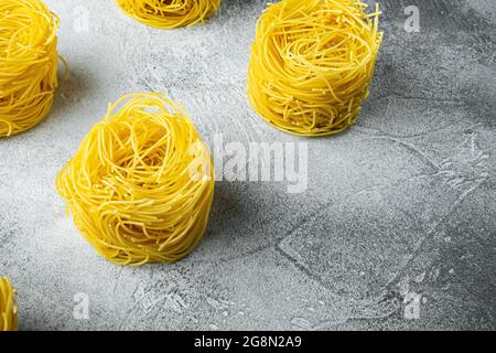 Dried taglierini set, on gray stone background, with copy space for ...