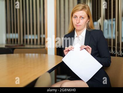 Upset female writing resignation letter Stock Photo - Alamy