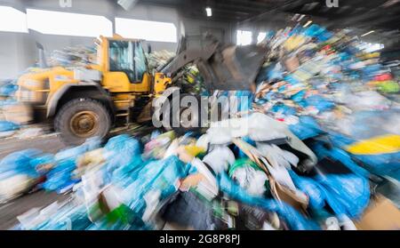 Wheel loader on the landfill site, pushing, scooping and carrying waste ...