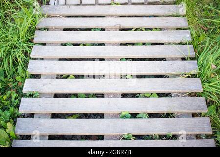 A wooden construction pallet is lying on the grass. Wood texture on the ...