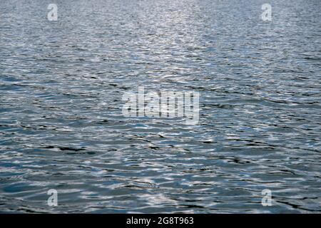 Beautiful diffused shimmer on a tranquil water surface with copy space ...