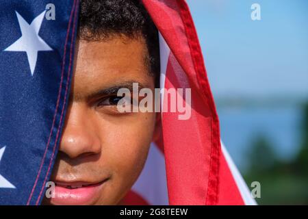 Happy man with national USA flag on red background. American patriot ...