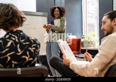 Middle aged african female teacher explaning new topic to students in ...