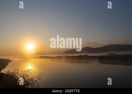 Beautiful sunrise over the Erciyes mountain and calm river on a misty ...