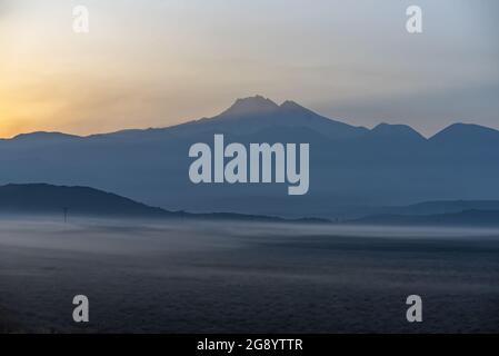 Beautiful sunrise over the Erciyes mountain and calm river on a misty ...
