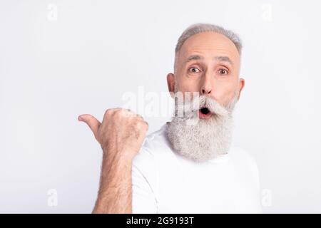Photo of amazed shocked old grandfather point finger thumb empty space ...