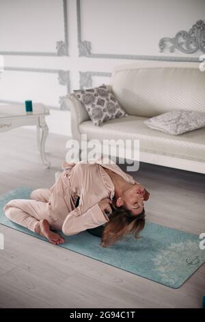 Young pretty lady doing asana at home on yoga mat Stock Photo - Alamy