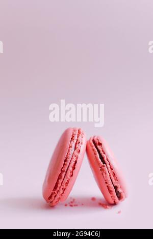 Two pink macaroons on blue wooden table Stock Photo - Alamy