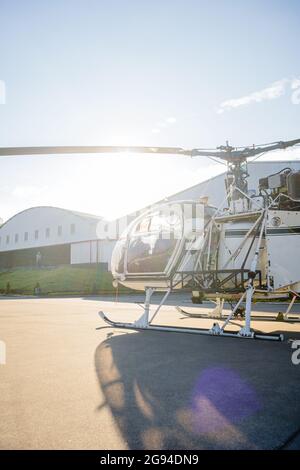 helicopter parked in an airport with a building behind Stock Photo - Alamy