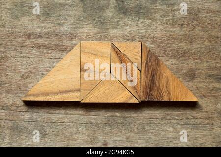 Tangram puzzle in trapezoid or trapezium shape on old white wood ...