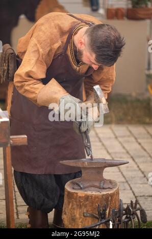 Blacksmith in medieval costume recreates the ancient craft of ...