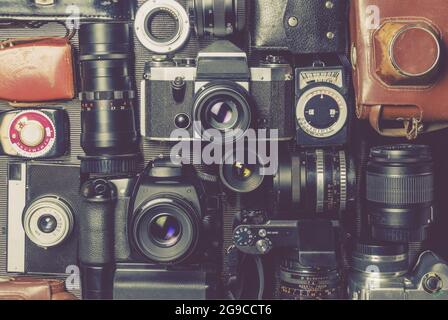 Old outdated photo cameras, lenses and exposure meters on wooden ...