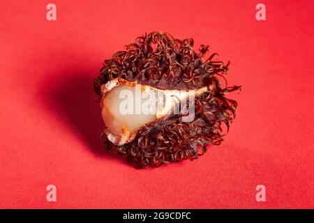 One whole fresh red rambutan on bamboo plate isolated on white ...