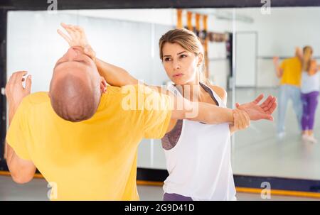 Ordinary female is fighting with trainer on the self-defense course for ...