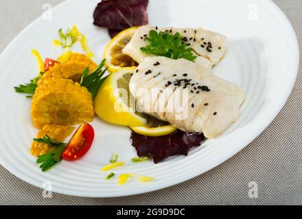 Hake steamed with corn, greens and lemon. Recipe Stock Photo - Alamy
