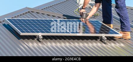 Unidentified man attaching solar panel to the roof rack with the ...
