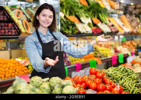 Female seller displaying assortment Stock Photo - Alamy