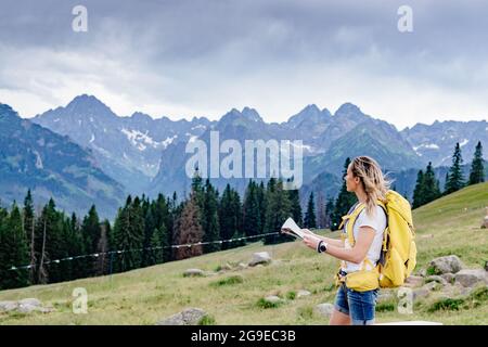 Adventurous woman navigating in with a topographic map in the beautiful ...
