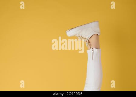 inverted legs in white sneakers fashion modern style yellow background ...