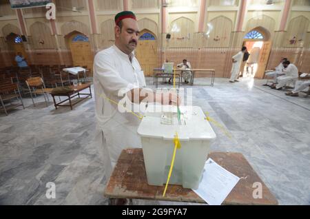 People stand in queue to cast their votes at a polling center during ...
