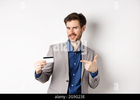 Successful male entrepreneur pointing at plastic credit card and ...