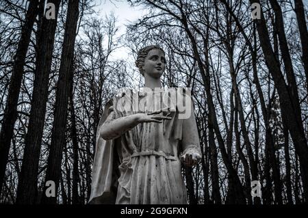 Antique statue of a dryad in the park among trees. Moscow, Russia ...