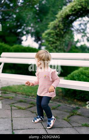 The little girl stands turning her back and staring at a large white ...