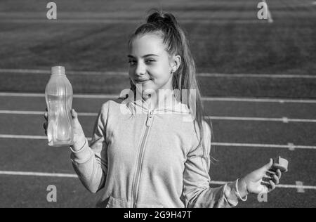 sprinter with bottle on stadium gym. thirsty and hydration. child ...