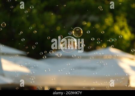 Soap Bubbles Scenery in sunset light with people in background. High ...