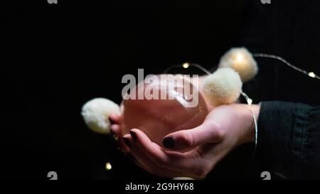 Closeup shot of hands holding a reflective ball and string lights Stock ...